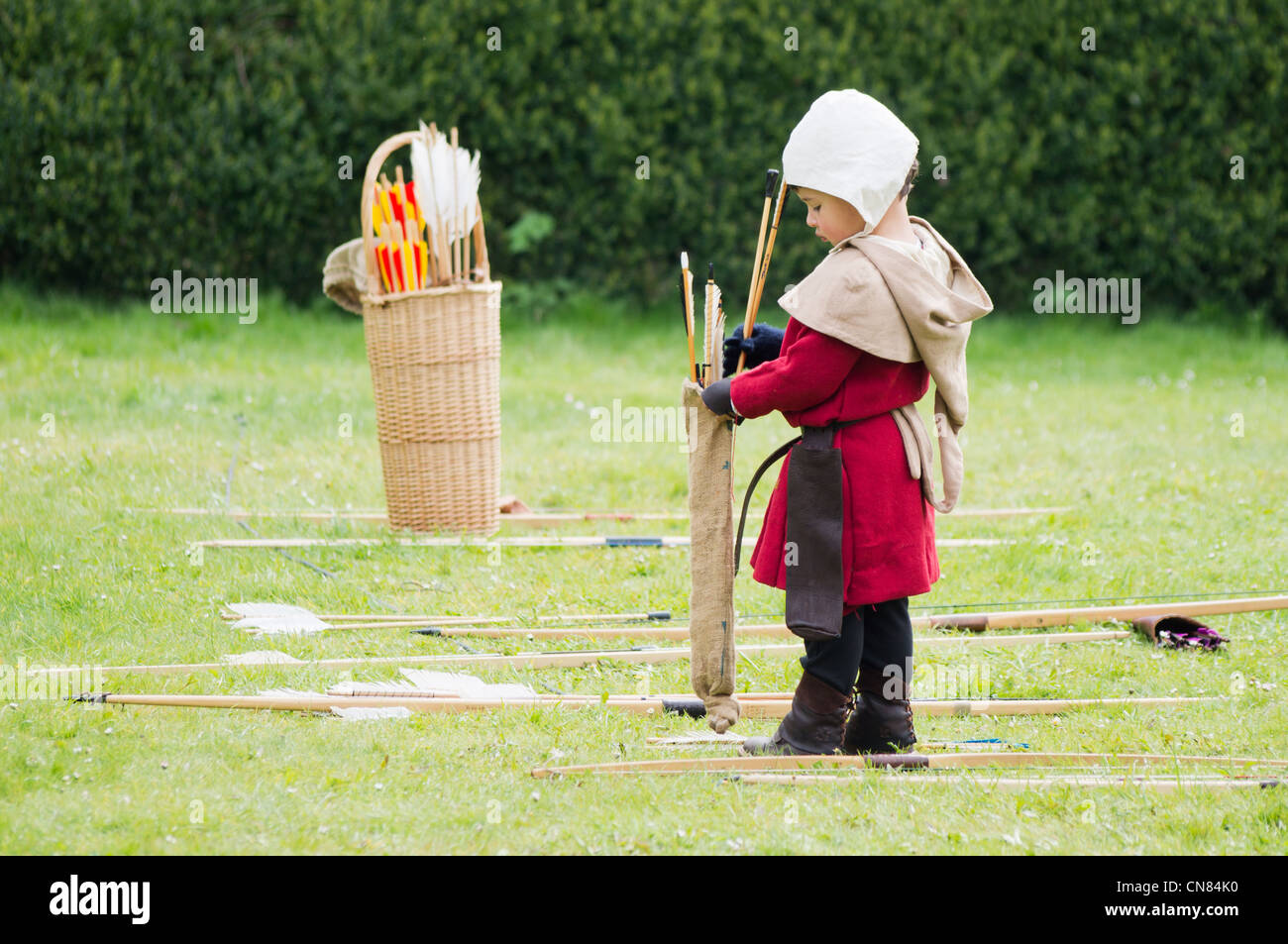 "History in action" re-enactment. A small medieval boy helps archers ...