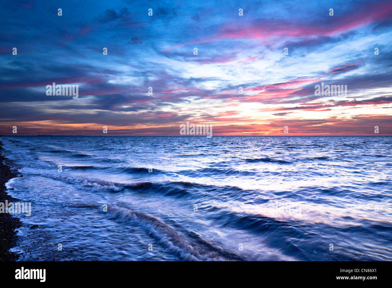 Winter sunset over the Wash showing brightly coloured cloud patterns ...