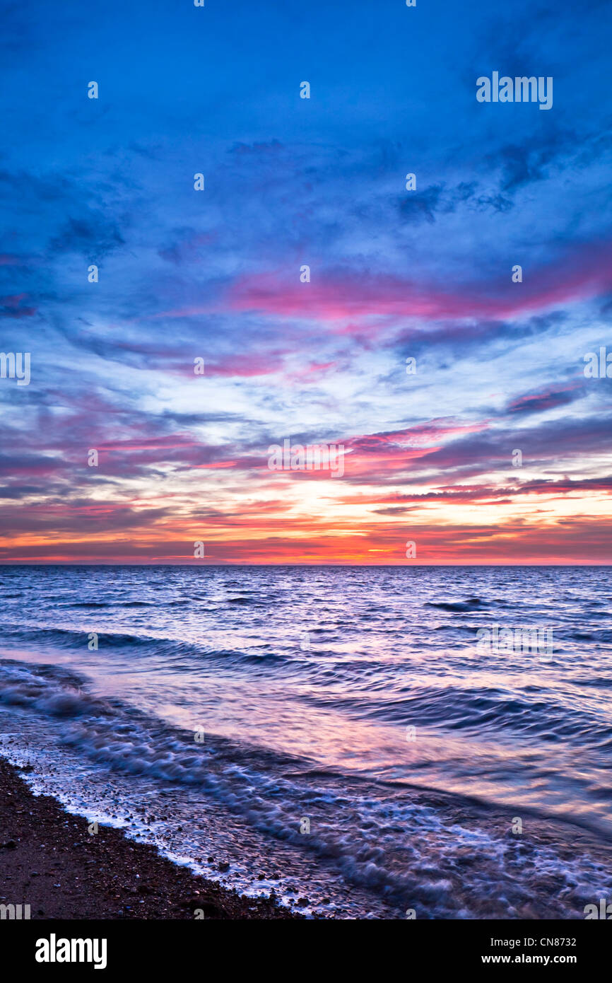 Winter sunset over the Wash showing brightly coloured cloud patterns ...