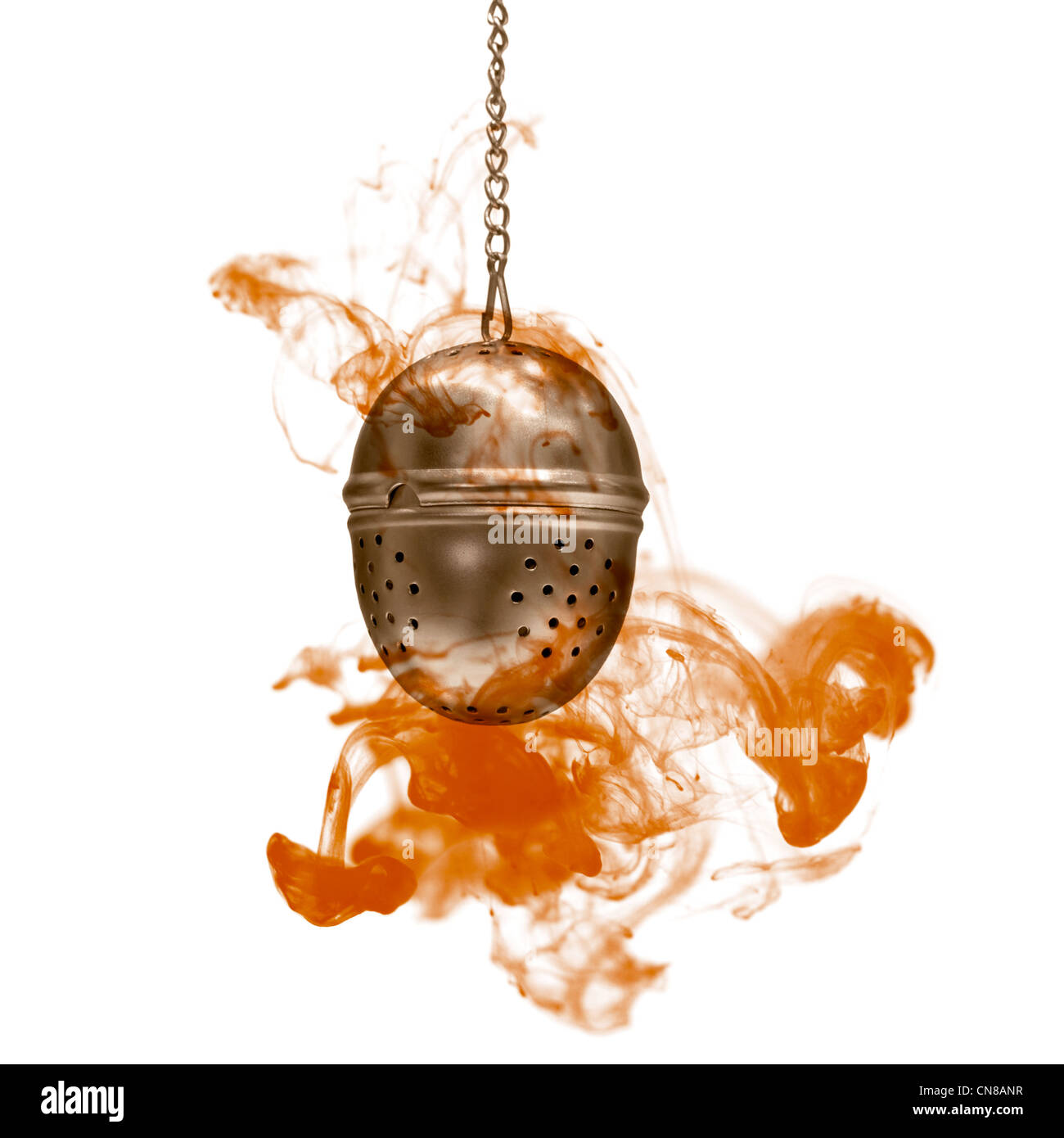 Tea is brewed in boiling water. Tea infuser isolated on white ...