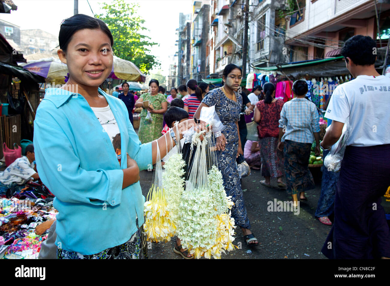 A young Burmese girl sells jasmine flower garlands in a street market on the streets of Yangon ...
