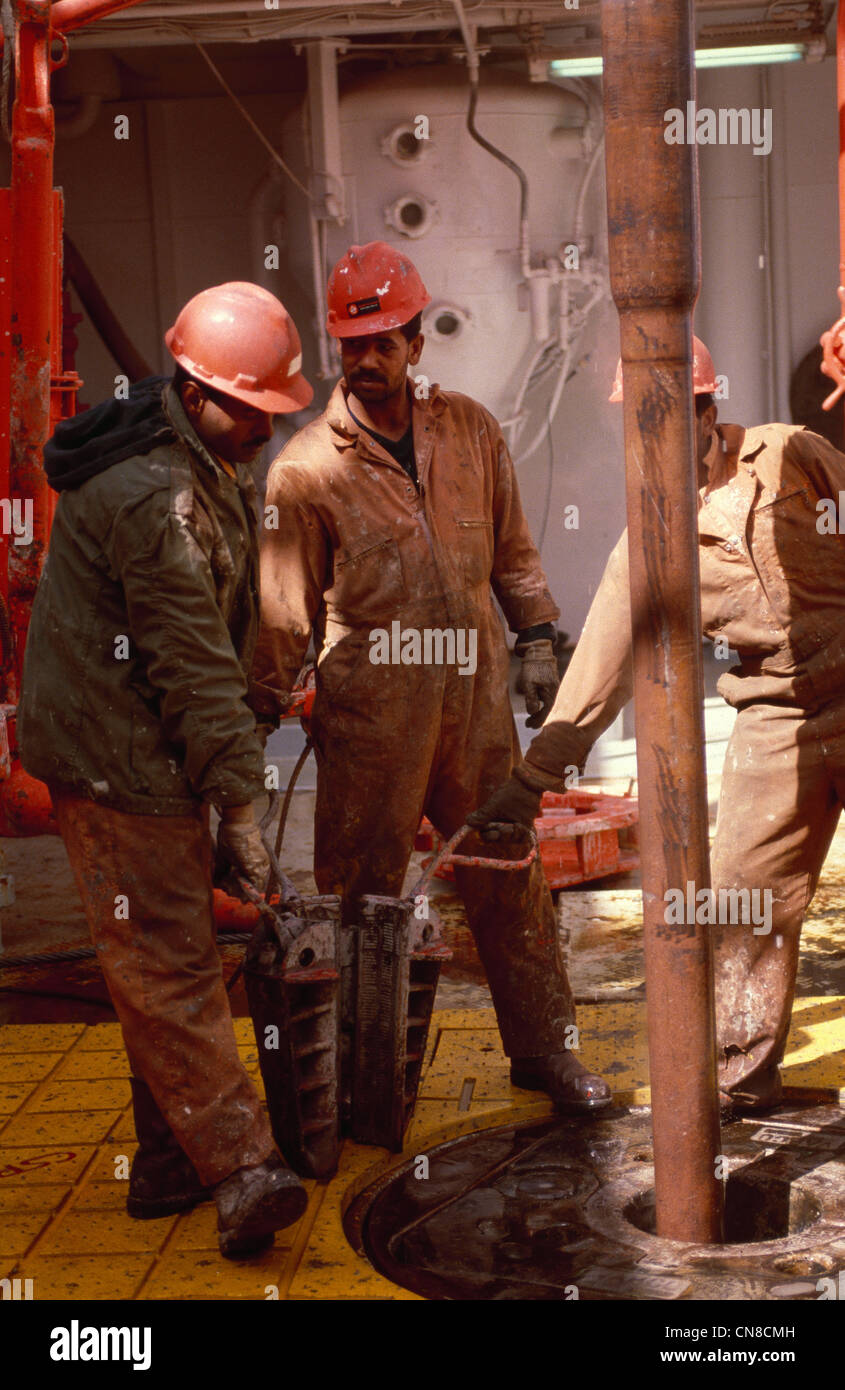 Roughneck action with drill pipe on the rig floor of an offshore ...