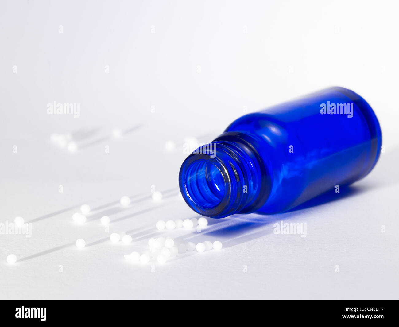 a open small blue bottle in light back with globules around Stock Photo ...