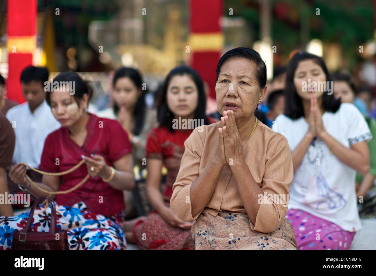 Burmese women pray in at the sacred Buddhist site of Shwedagon Paya ...