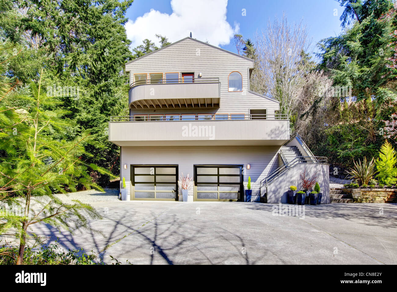 Light brown modern house exterior in spring forest with cherry blossom ...