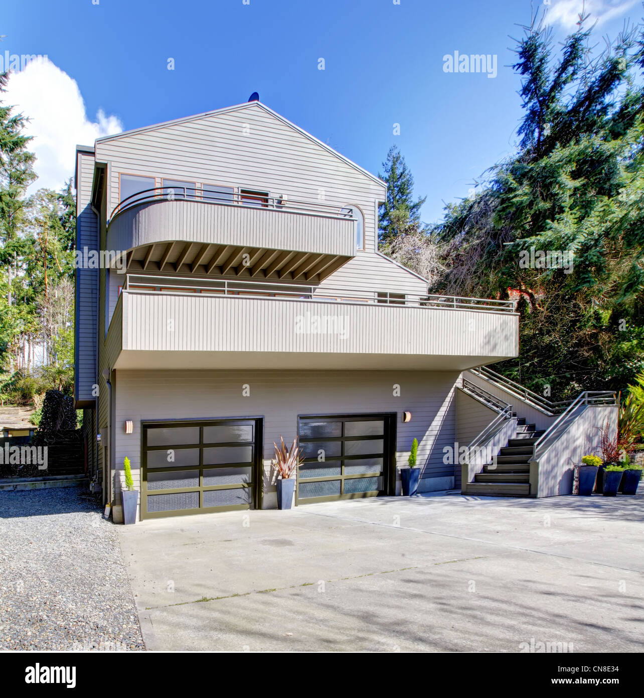 Light brown modern house exterior in spring forest with cherry blossom ...