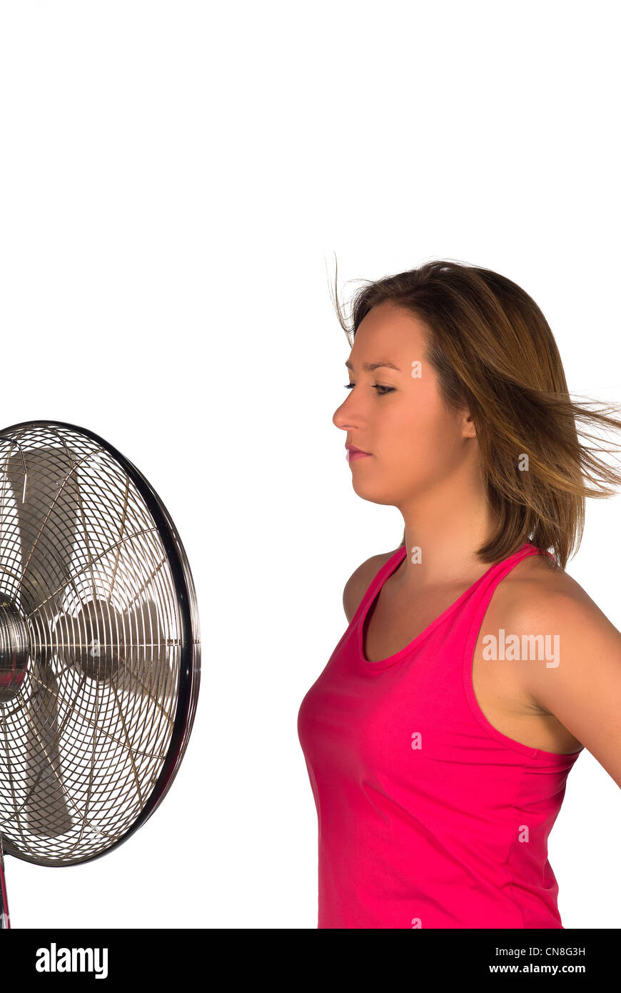 Blond girl standing next to a moving fan Stock Photo - Alamy