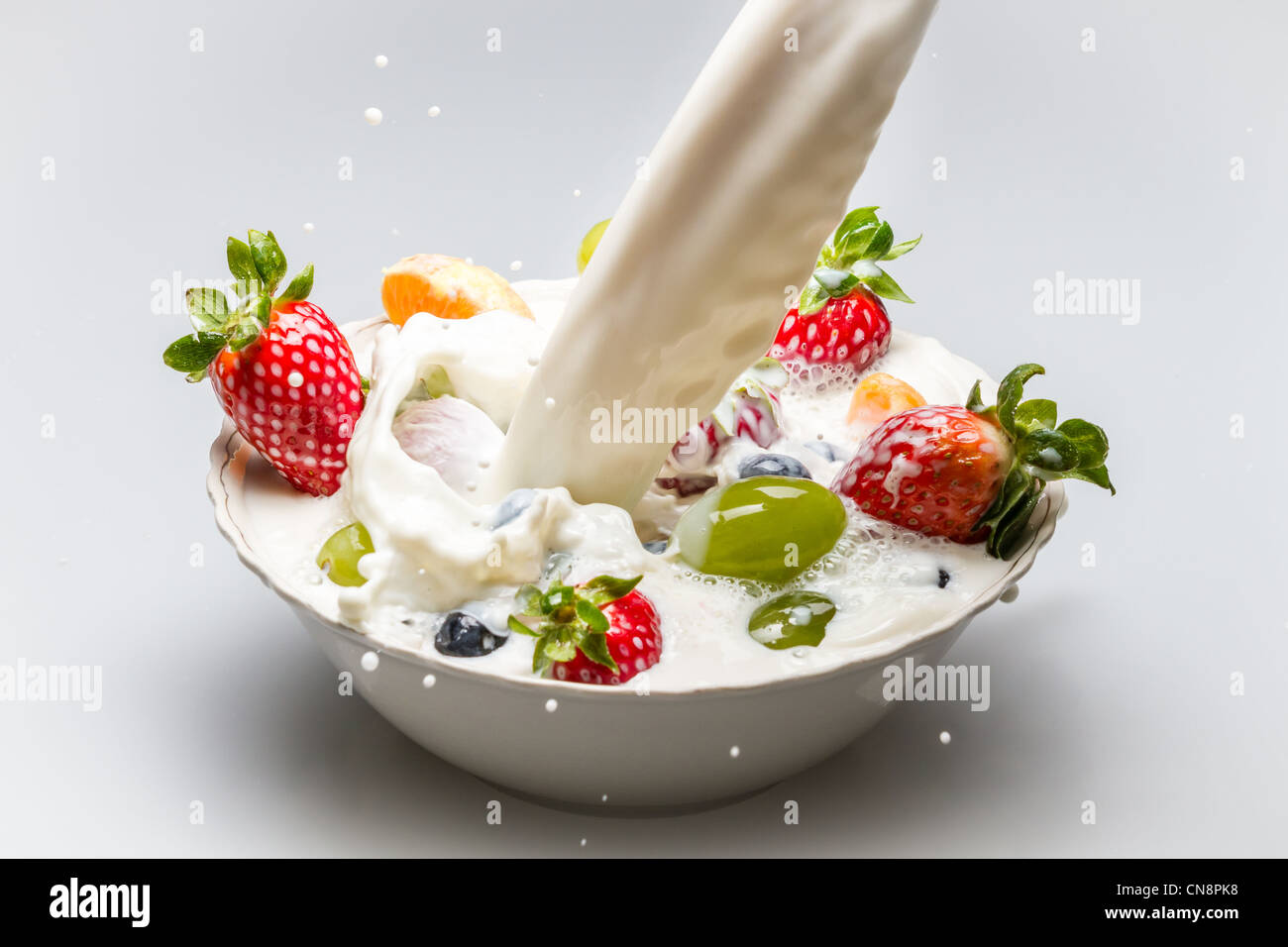 Milk pouring into fresh fruits Stock Photo - Alamy