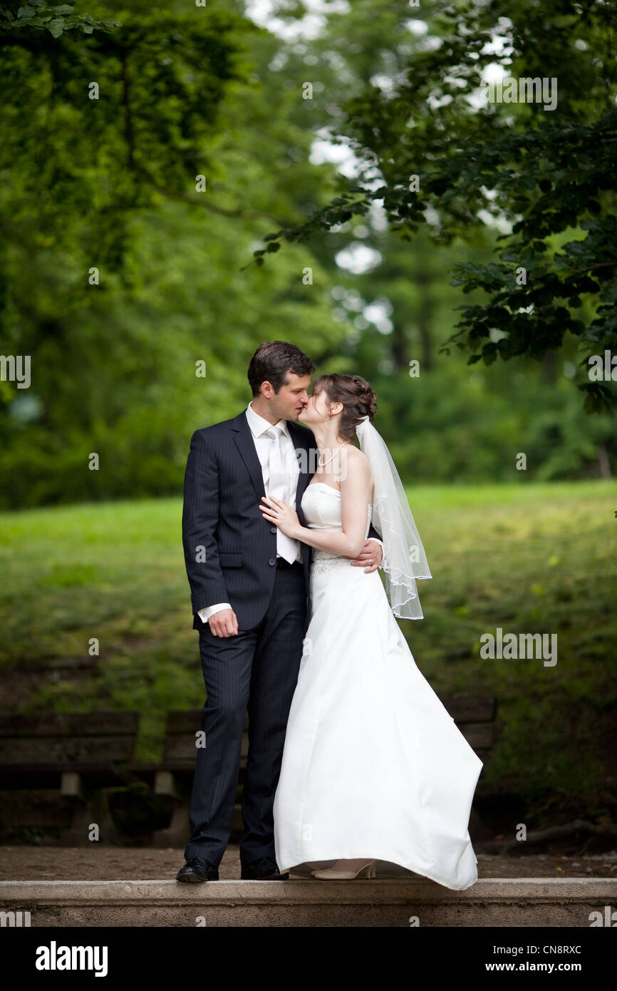 young wedding couple - freshly wed groom and bride posing outdoors on ...