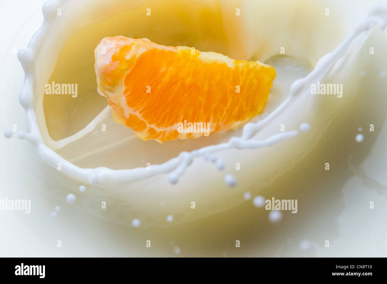 Closeup mandarin flowing into milk Stock Photo - Alamy