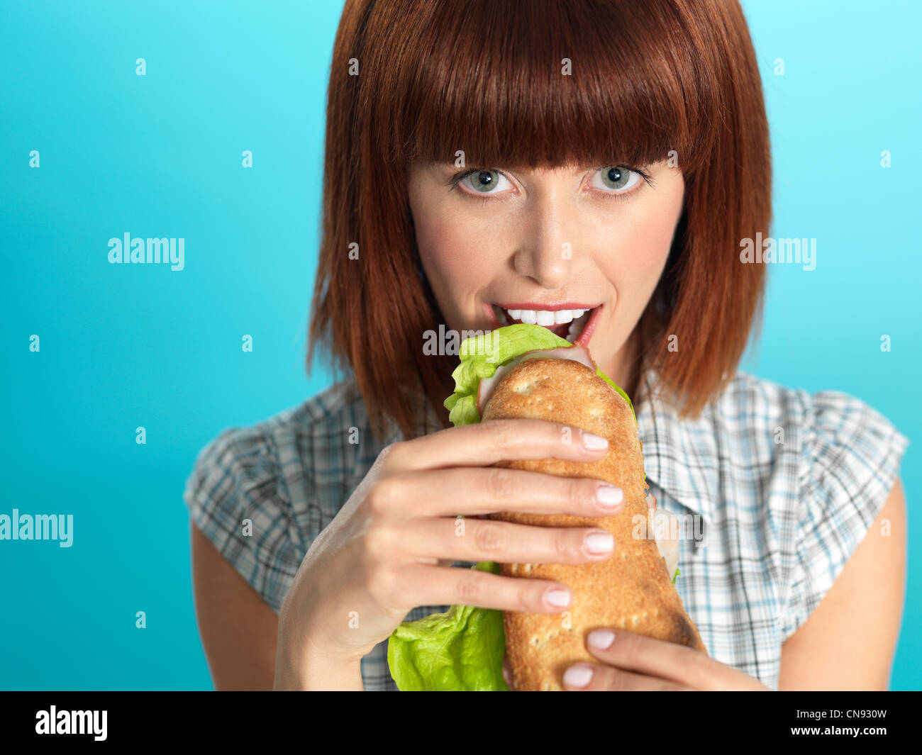 closeup portrait of beautiful young woman, eating a big sandwich ...