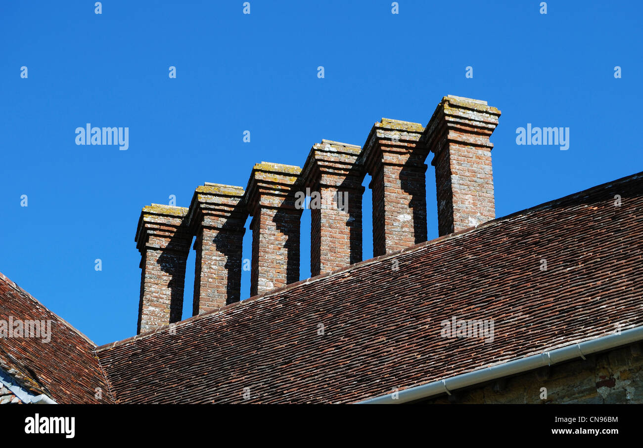 Six brick chimneys in a row on old english house in Sussex. England ...