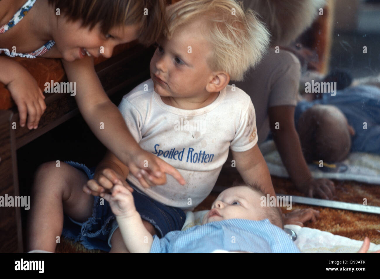 three children together engaging Stock Photo - Alamy
