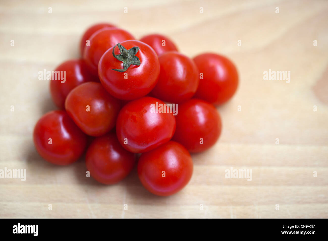 Small tomatoes on table desk. Fresh vegetable Stock Photo - Alamy