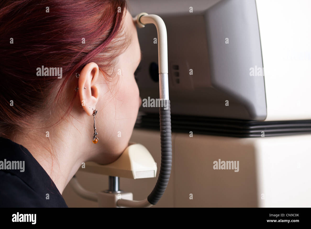 Beautiful young woman having computer eye test. At the optometrist ...