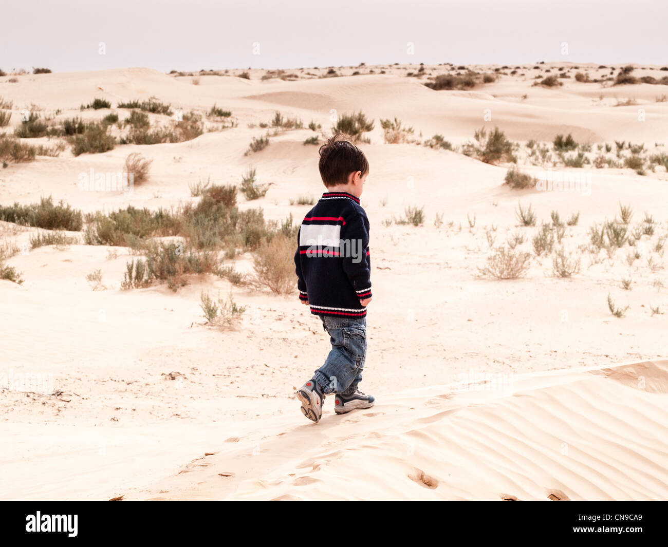 children play whit sand in the desert Stock Photo - Alamy