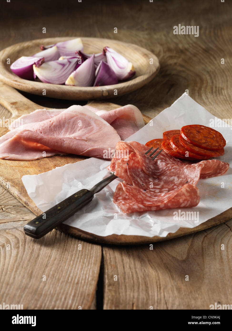 Sliced cured meats with red onion Stock Photo - Alamy