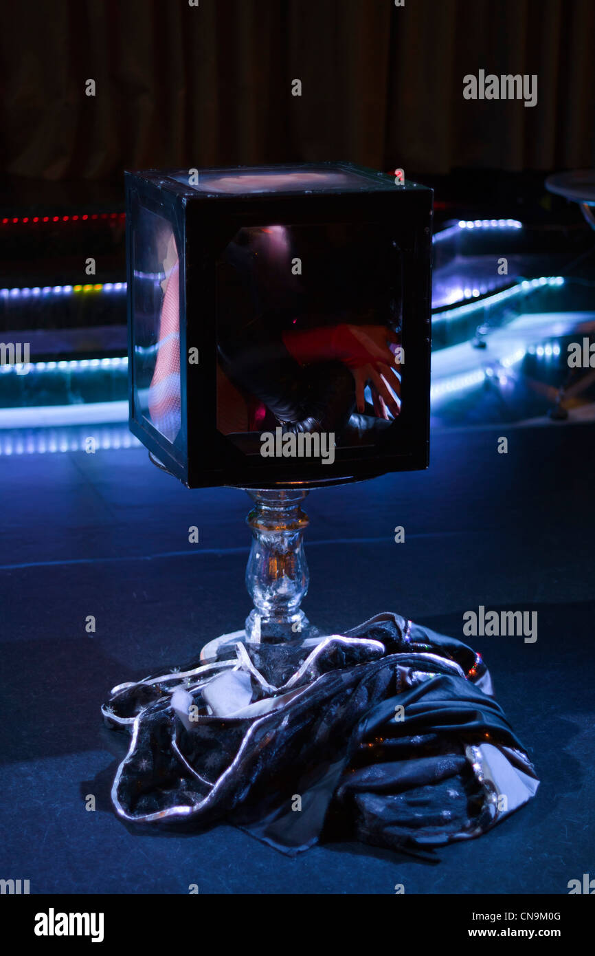 Contortionist woman enters-exits small cube, hotel cabaret show. Gran ...