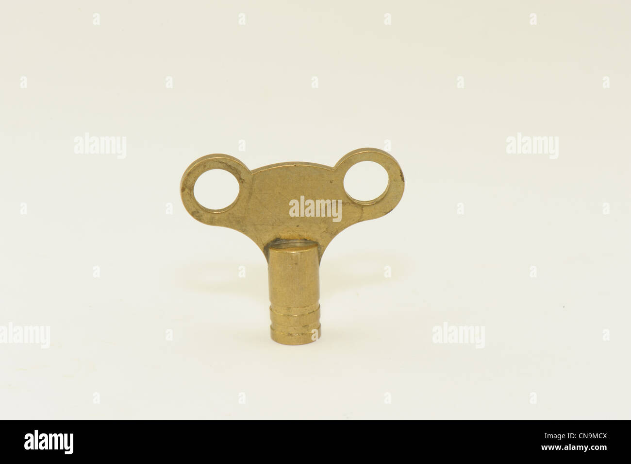 key brass wing nut design for winding mechanical clock taken on a white ...