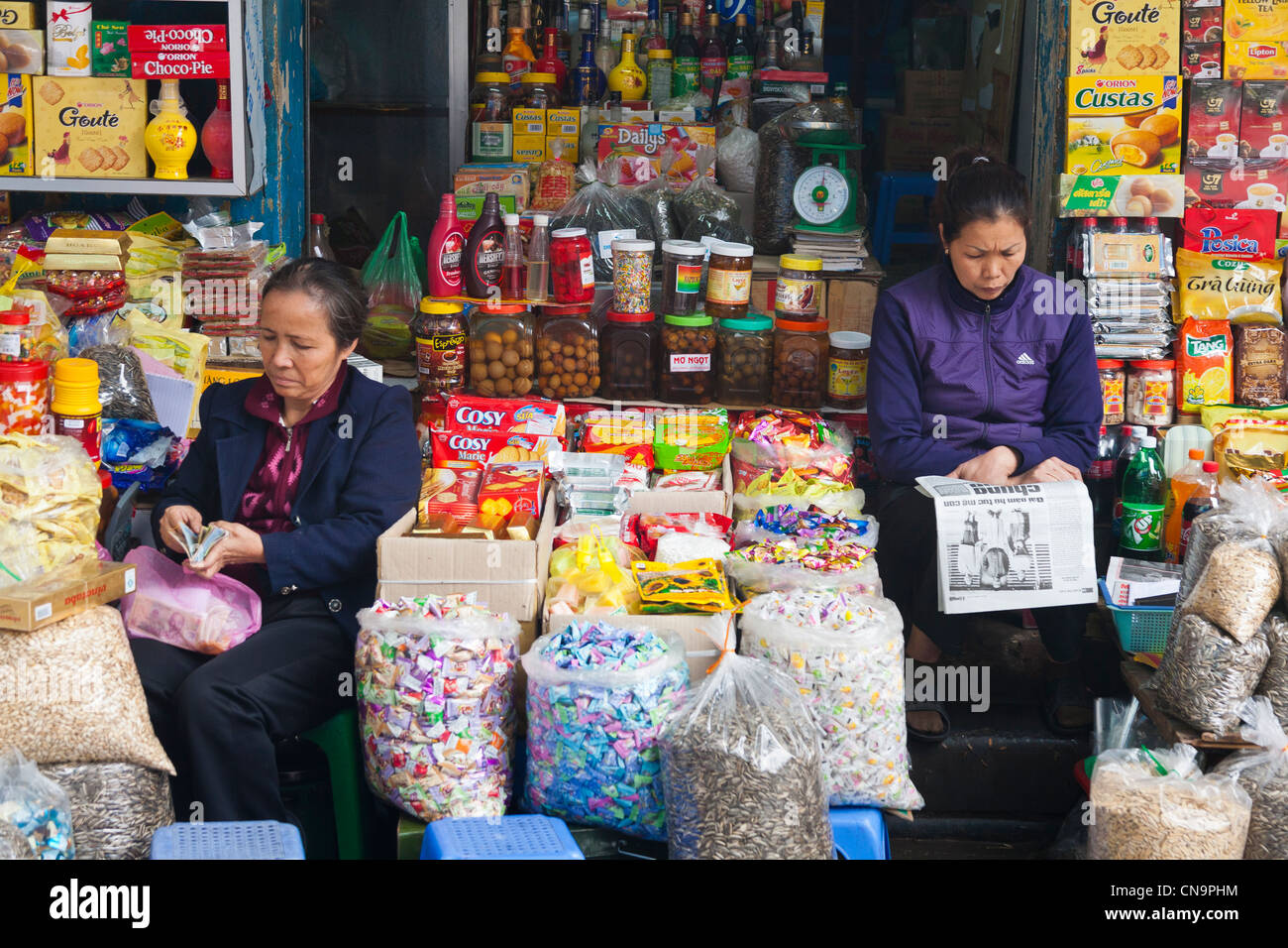 Women shopkeepers selling food outside a shop in the old town, Hanoi ...