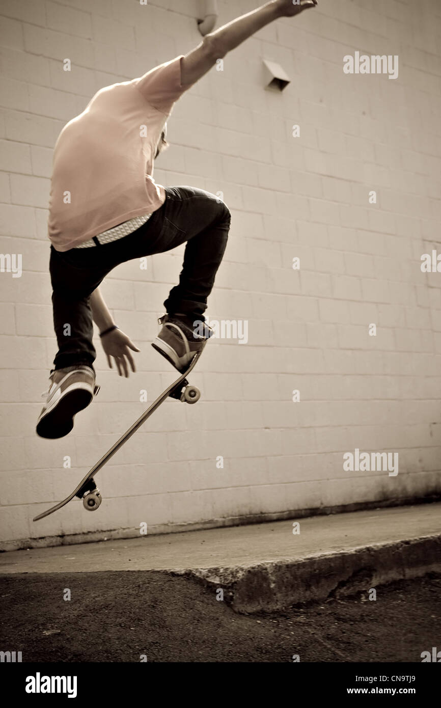 A young skateboarder doing a stunt in an urban area Stock Photo - Alamy