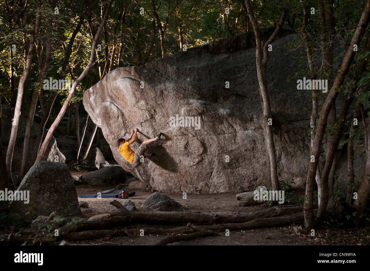 Rock climber scaling boulder face Stock Photo - Alamy