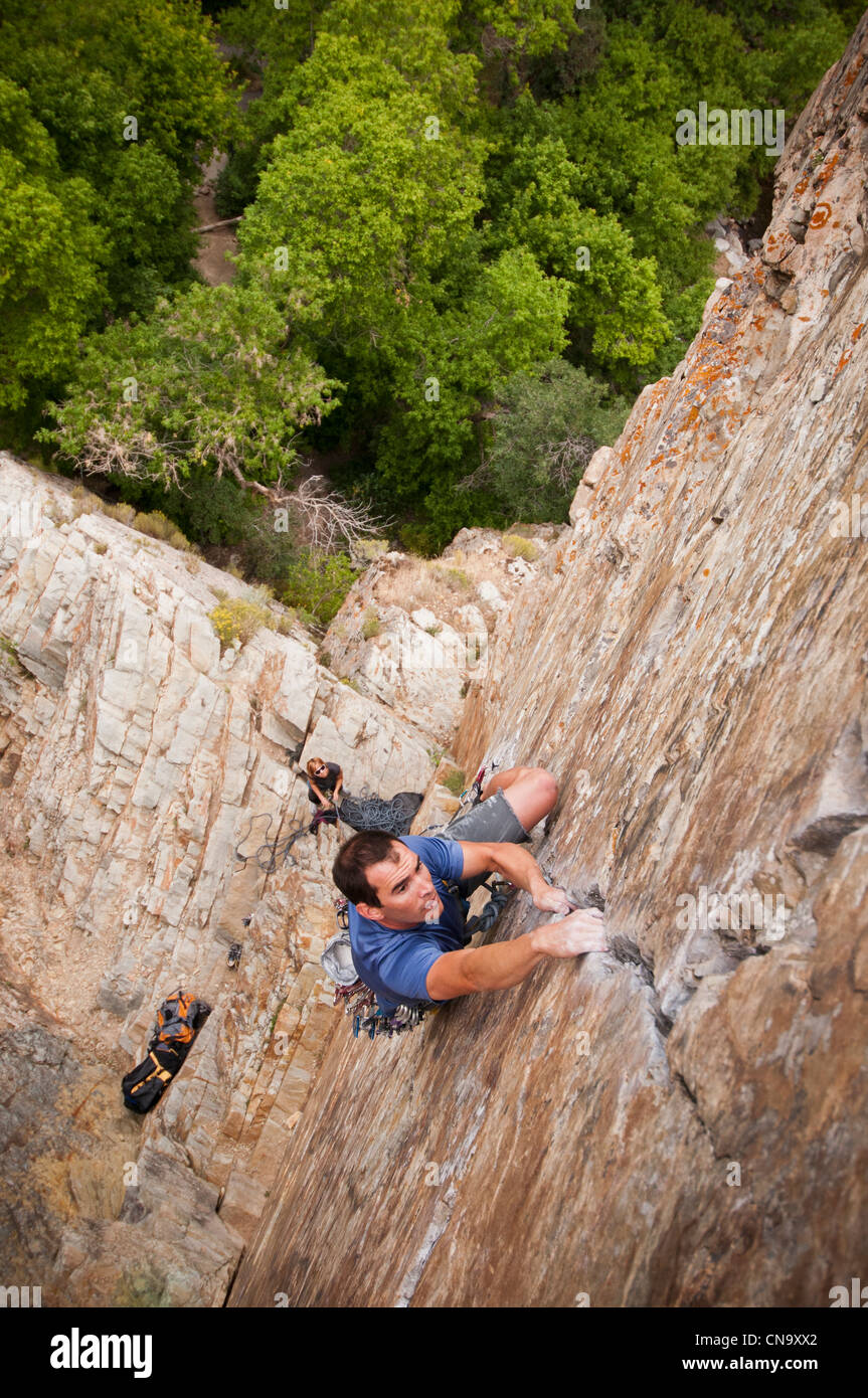 Rock climber scaling boulder crack Stock Photo - Alamy