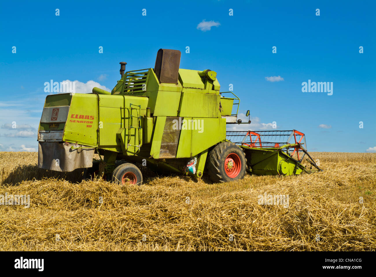Large green combine harvester during harvest Derbyshire Peak district ...