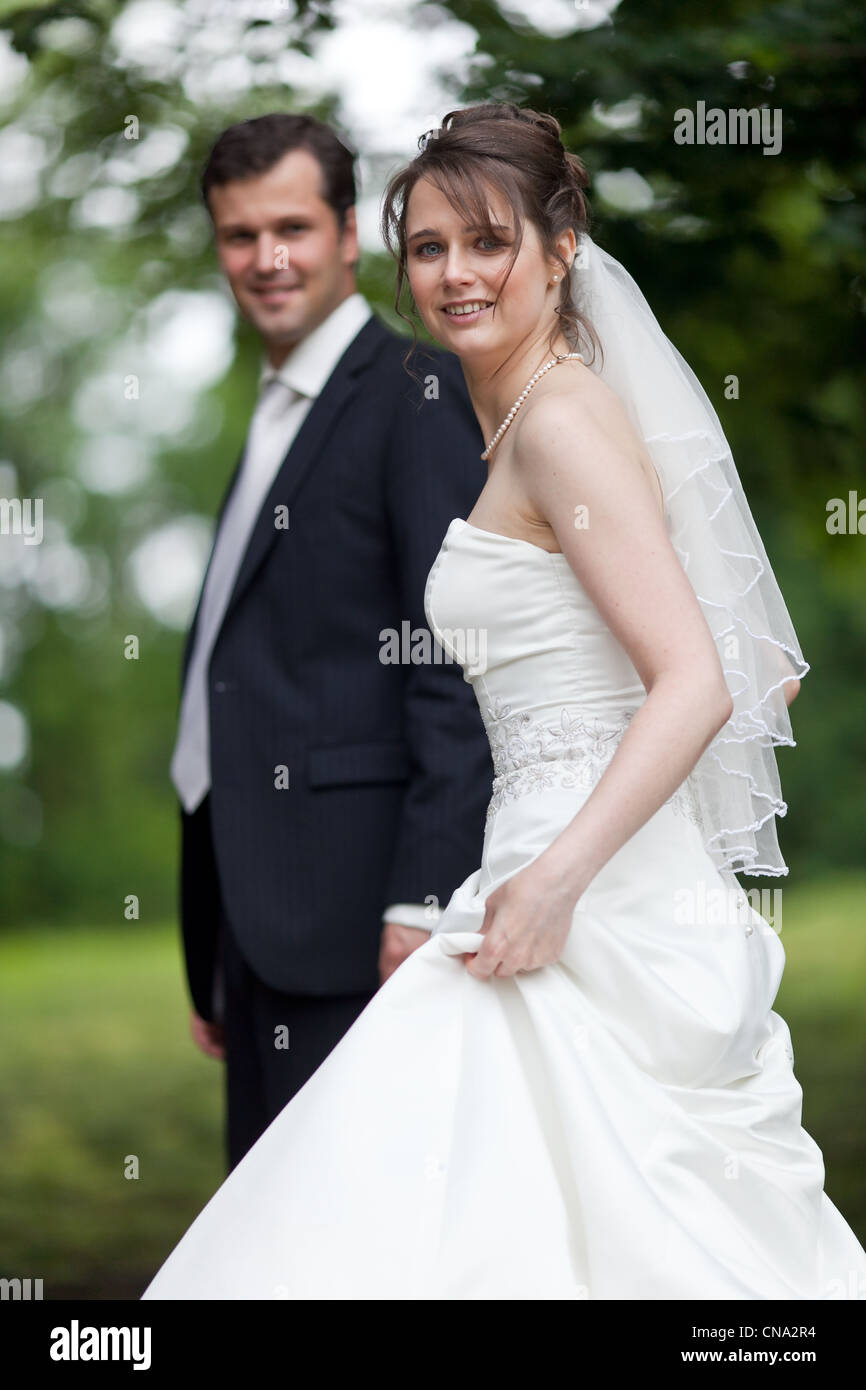 young wedding couple - freshly wed groom and bride posing outdoors on ...