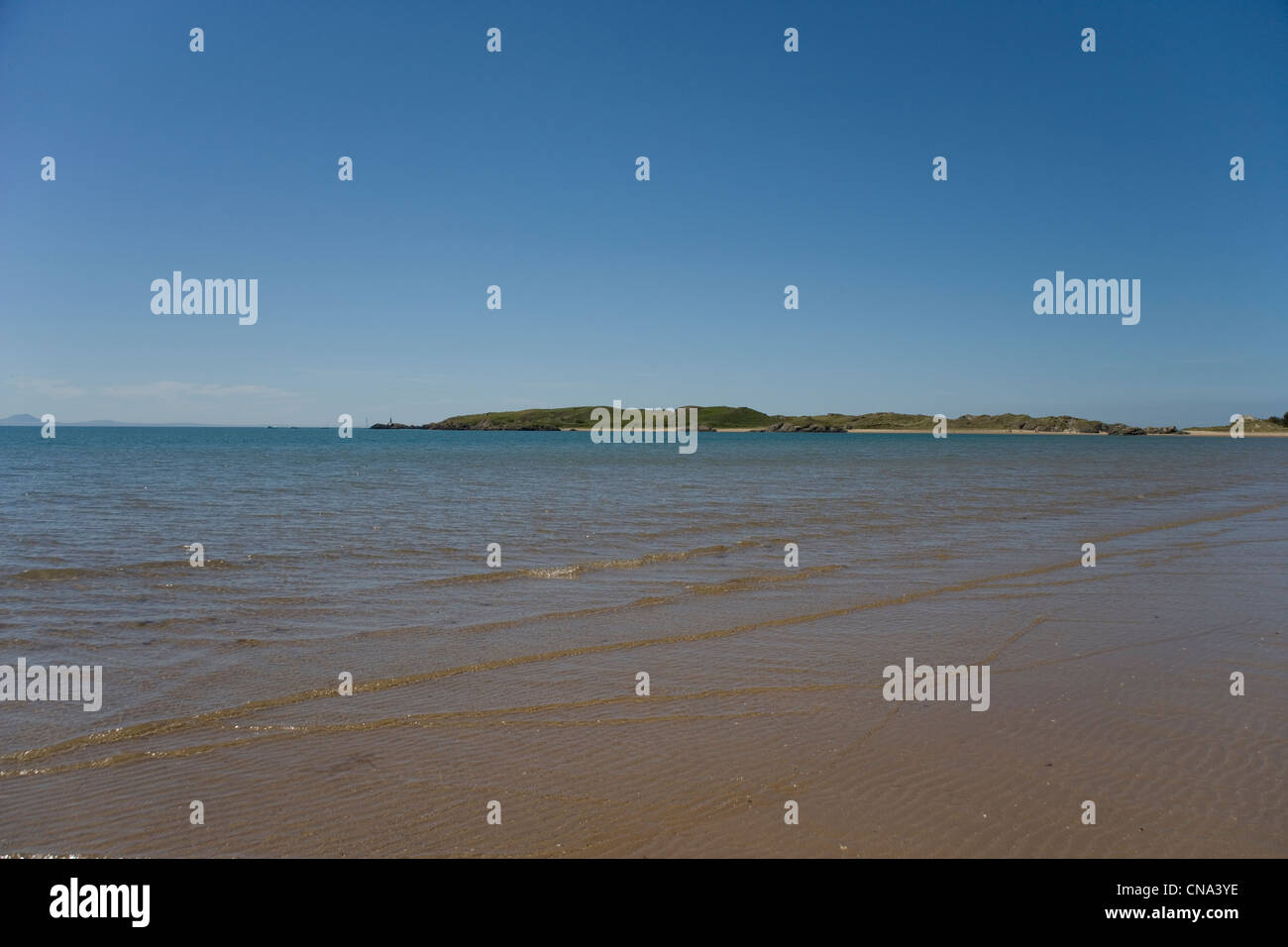Llanddwyn island and lighthouse from the beach at Traeth Llanddwyn on ...