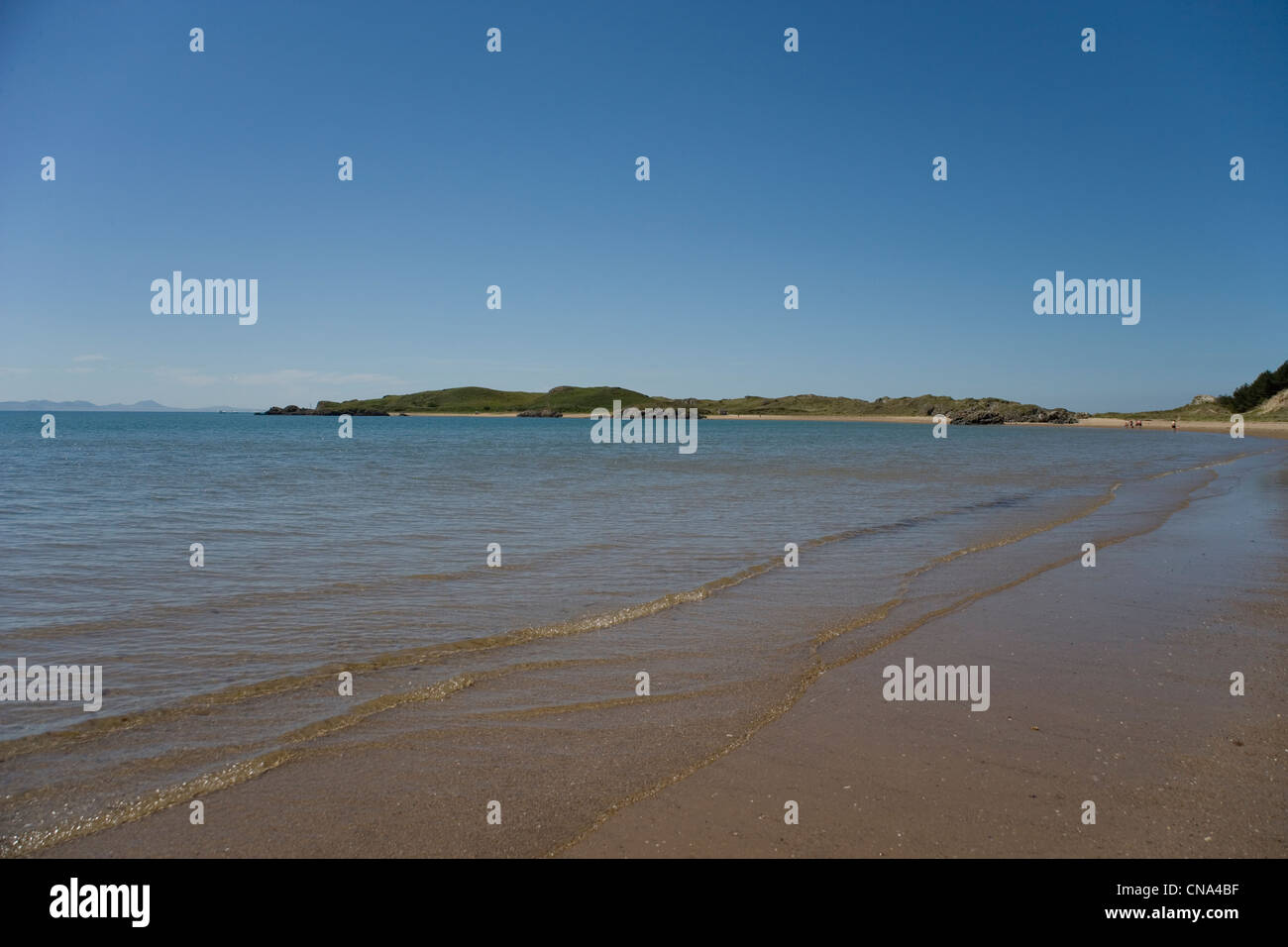 Llanddwyn island and lighthouse from the beach at Traeth Llanddwyn on ...