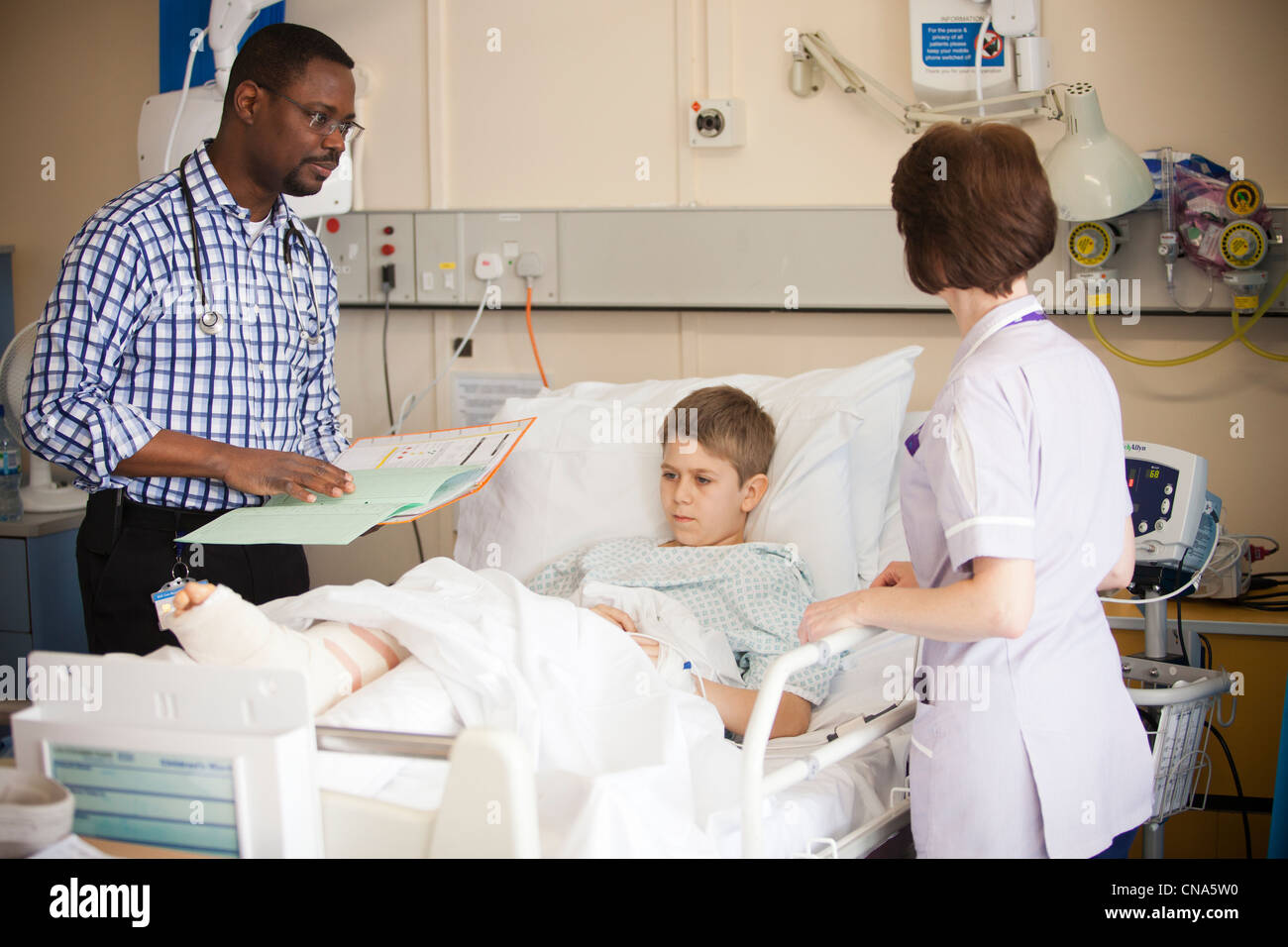 A young boy is checked by a doctor and nurse on a children's hospital ...