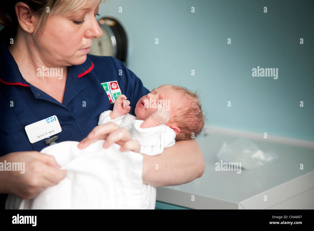 A midwife gets to cuddle a new born baby UK Stock Photo - Alamy