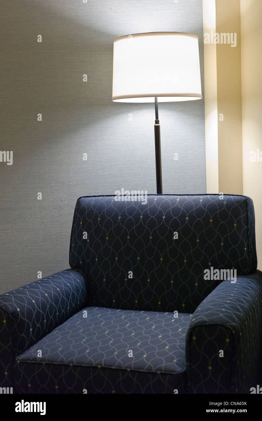 Interior night view of reading lamp and chair in an upscale hotel room ...