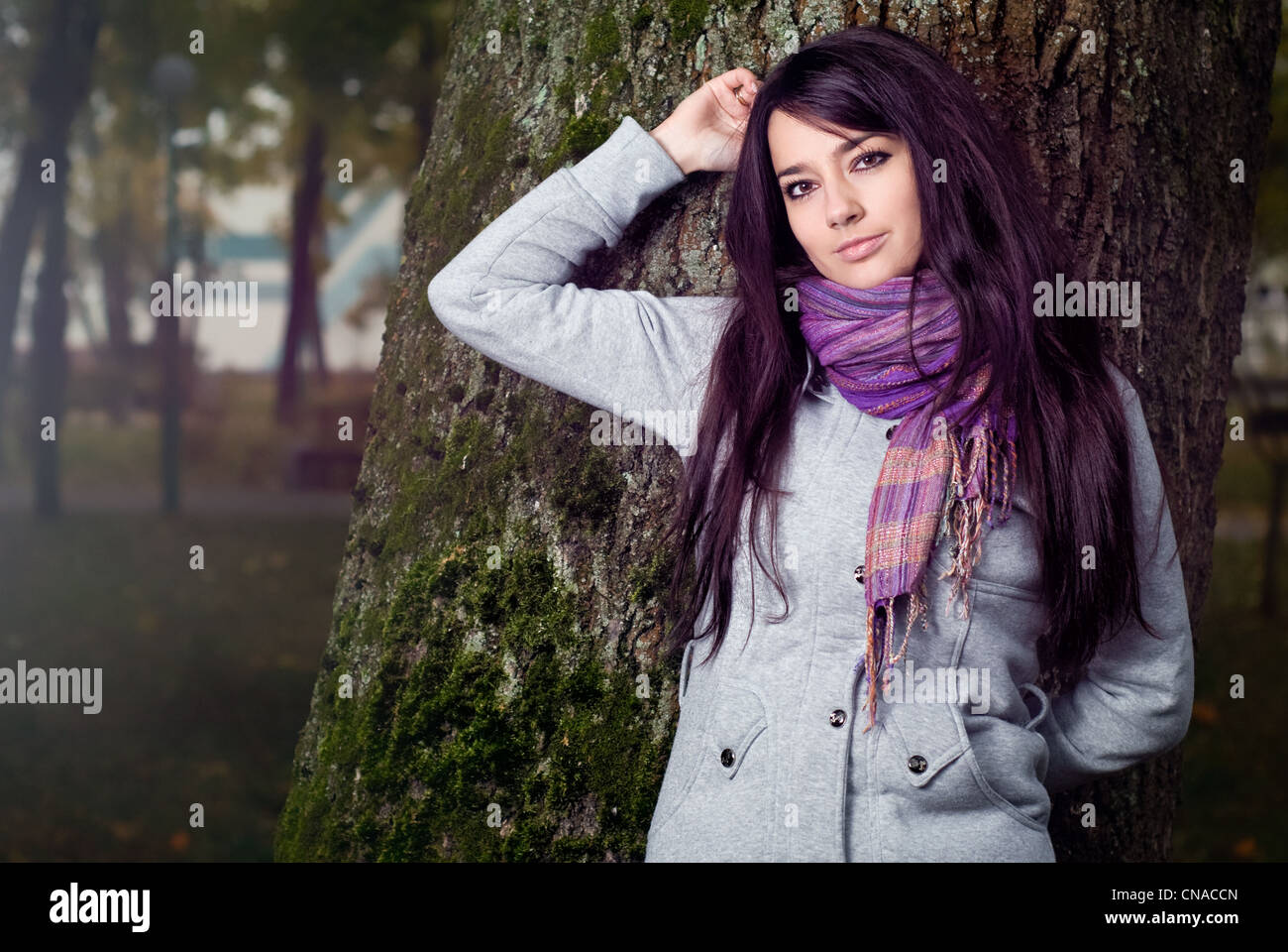 Portrait of beautiful model leaning to tree Stock Photo - Alamy