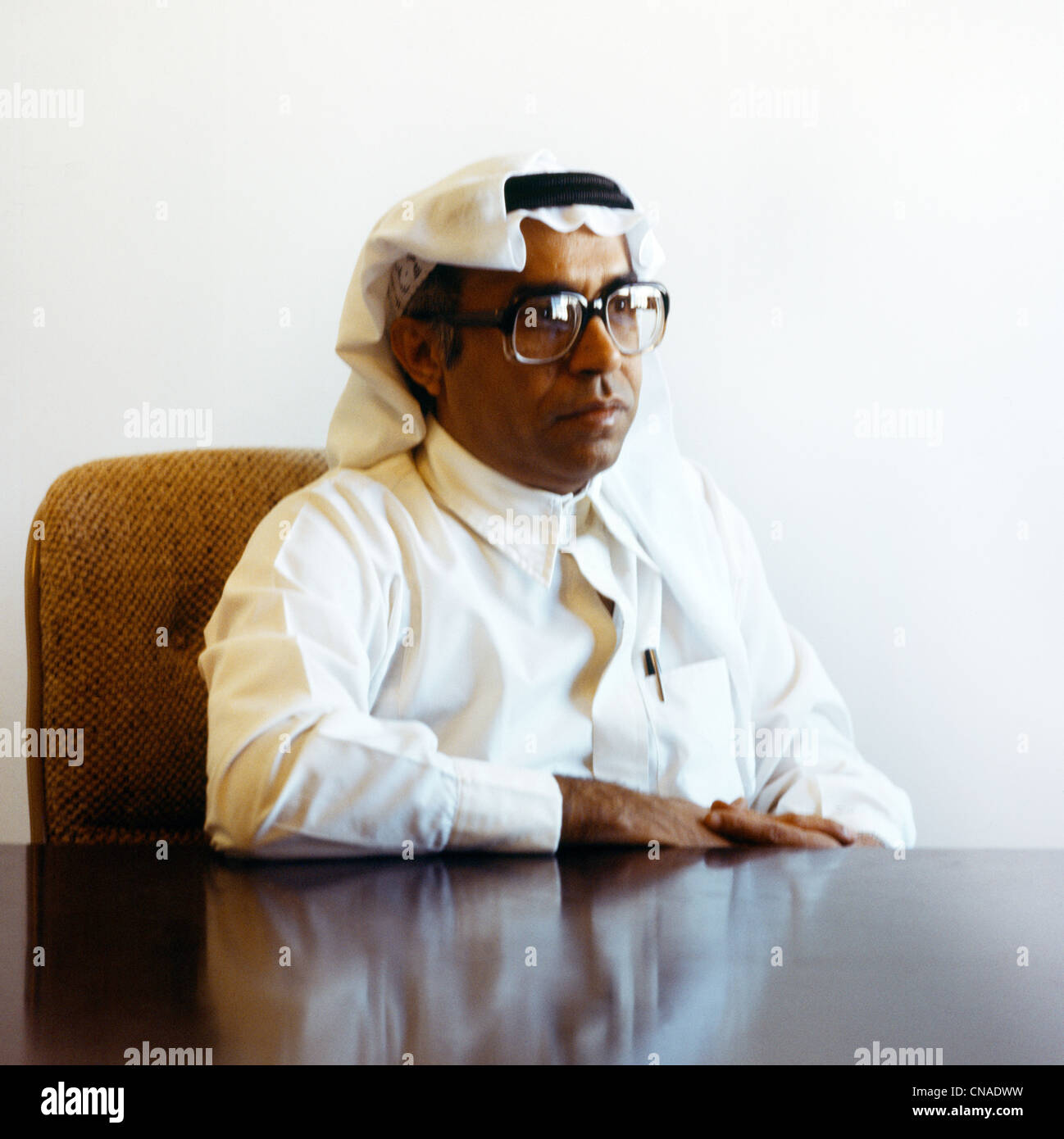 Saudi Arabia Saudi Man Wearing Dish Dash And Glasses Sitting At A Desk ...