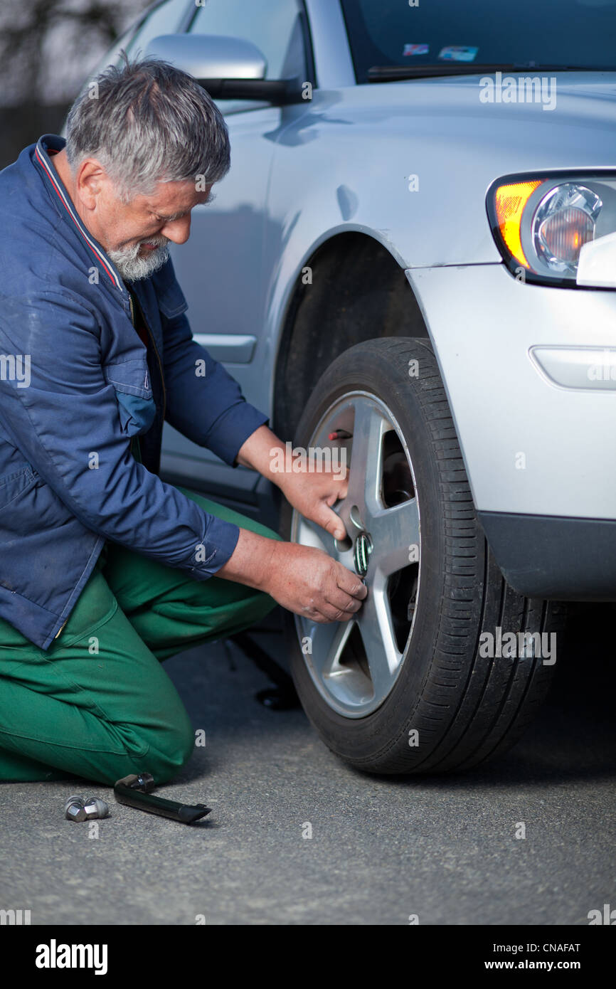 mechanic changing a wheel of a modern car (shallow DOF; color toned ...