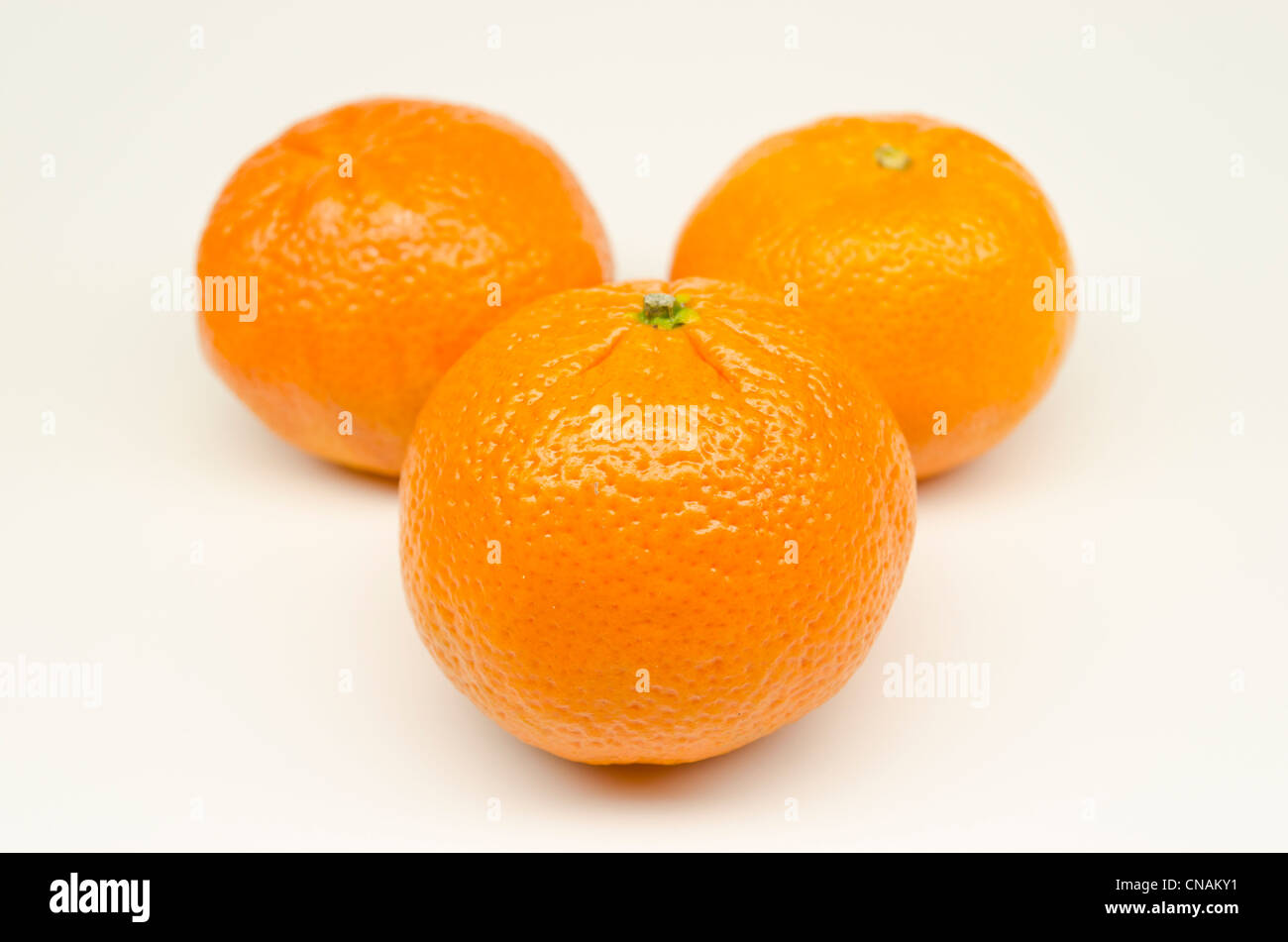Three oranges on white background Stock Photo - Alamy