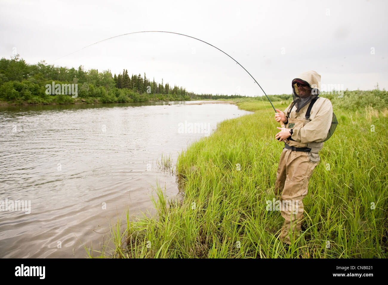 Fly fisherman wearing mosquito protection fishes for salmon on the ...