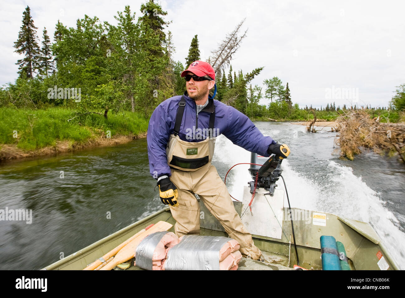 Sportfishing guide drives powered skiff on the Koktuli River in the ...