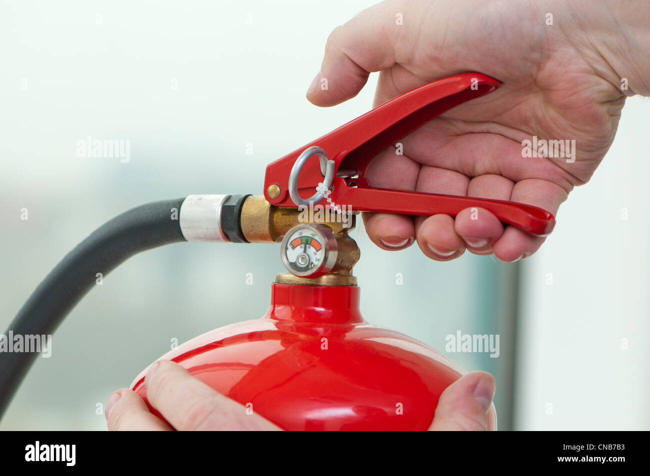 white hand presses the trigger fire extinguisher Stock Photo - Alamy