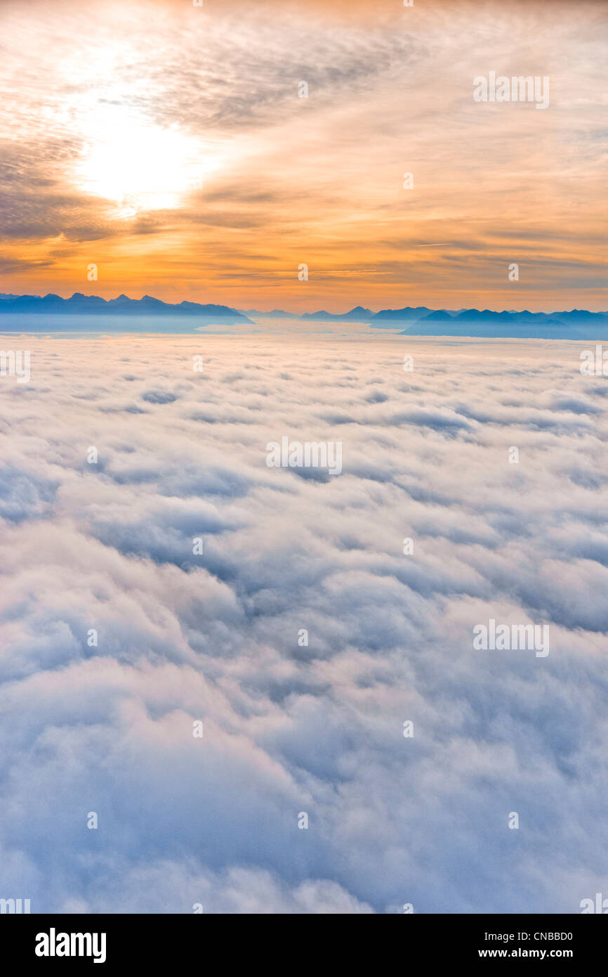 Aerial photo of the sun rising above the Chugach Mountains with fog ...