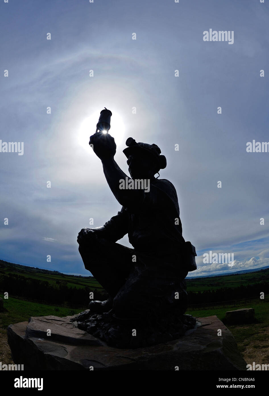 Bronze memorial statue of a coal miner holding up a Davy safety lamp in ...