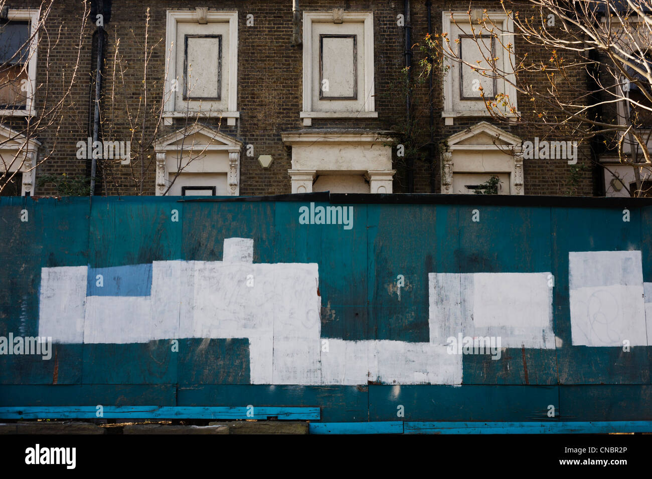 A derelict Victorian house boarded-up with similar patterns to that of ...