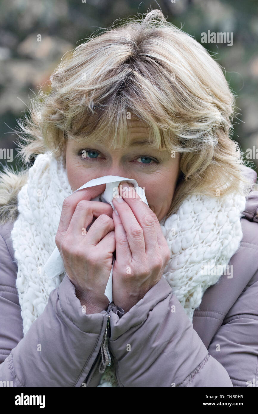 Freezing woman blowing her nose Stock Photo - Alamy