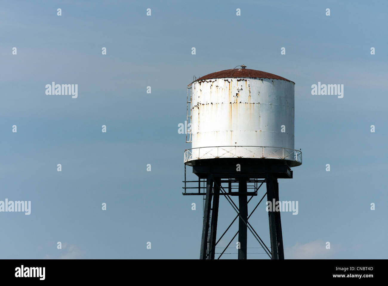 An old rusted water tower isolated over an empty blue sky Stock Photo ...