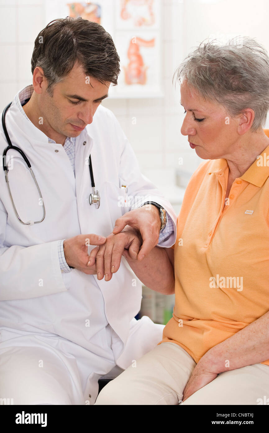Doctor examining hand of a female patient Stock Photo - Alamy