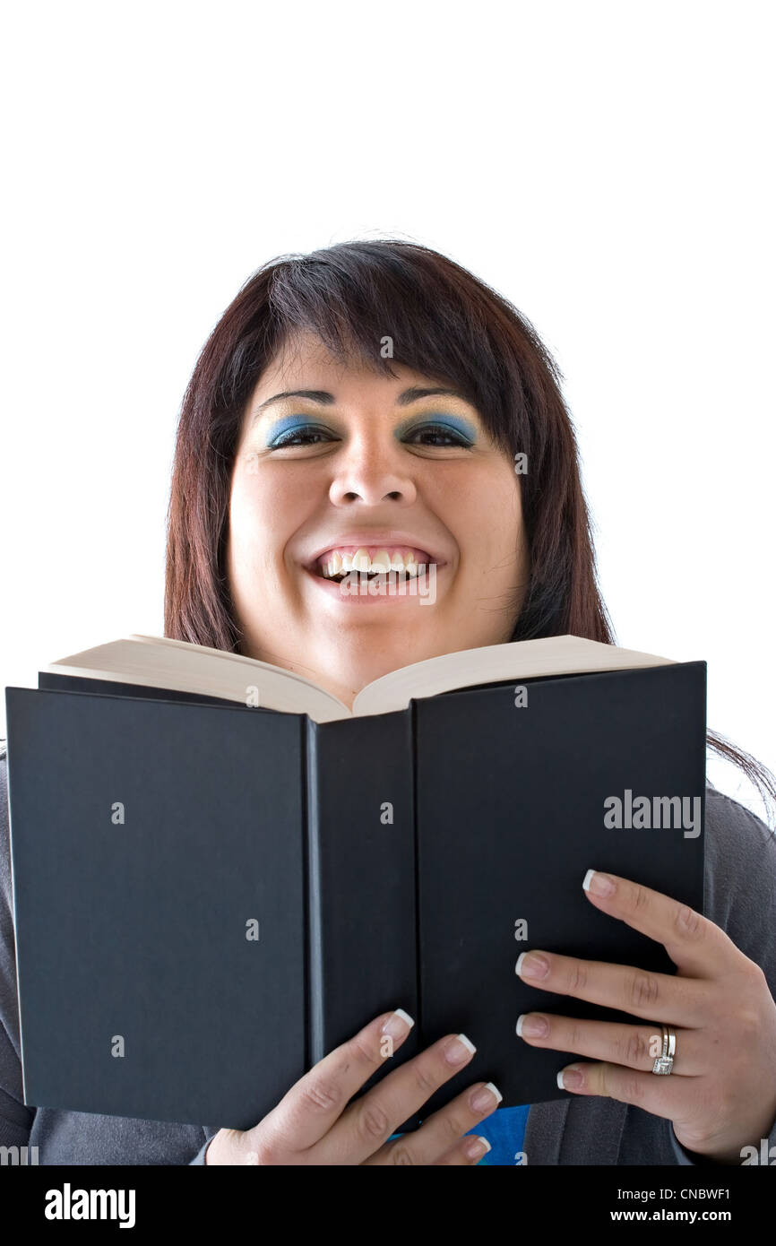 A young woman smiling as she reads a book Stock Photo - Alamy