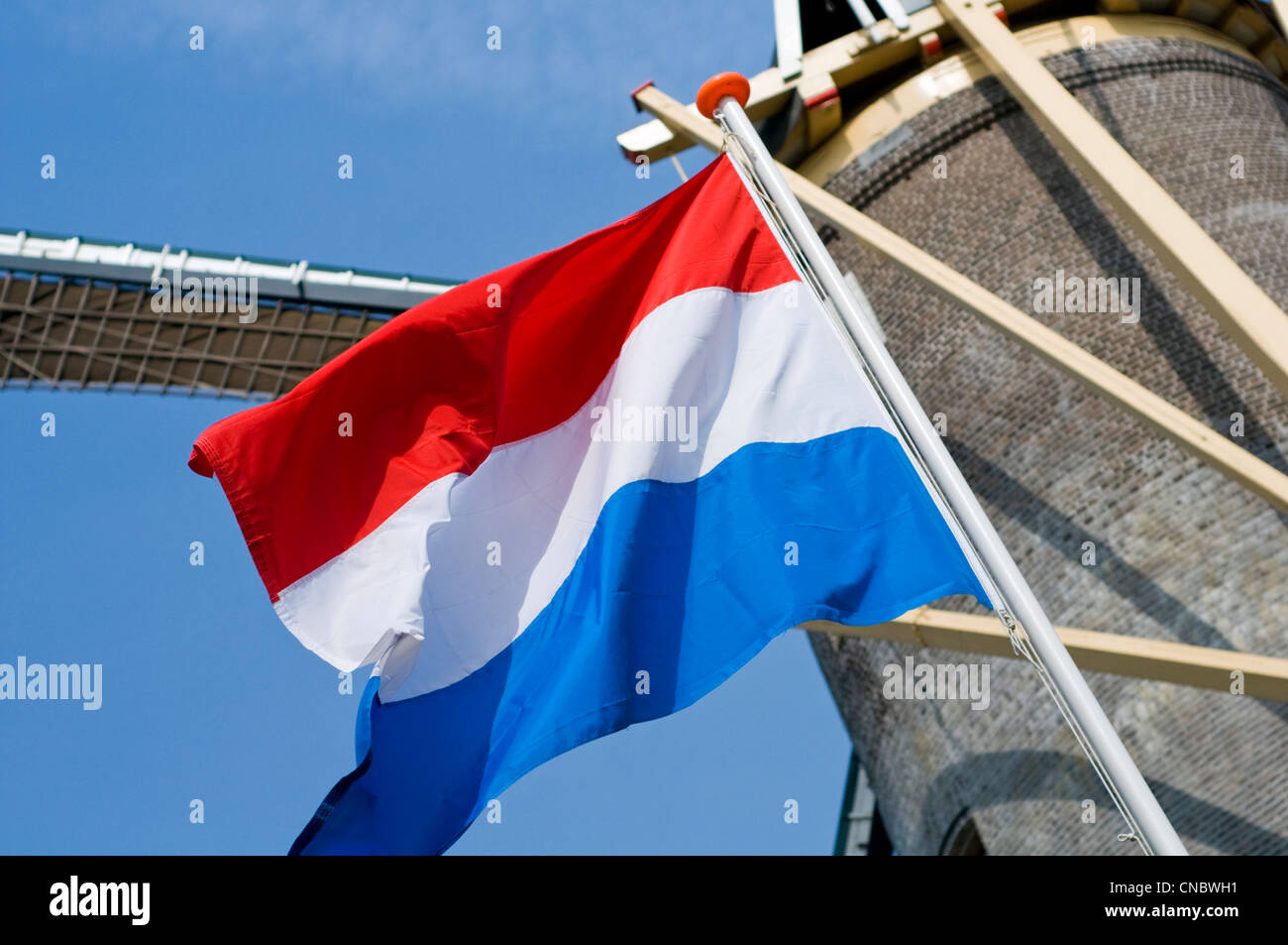 The Dutch flag flying in front of a windmill in the Netherlands Stock ...