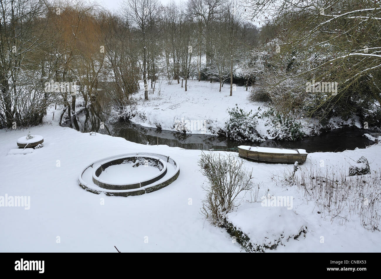 A snowy landscape, a river with a boat on the shore in winter (North ...